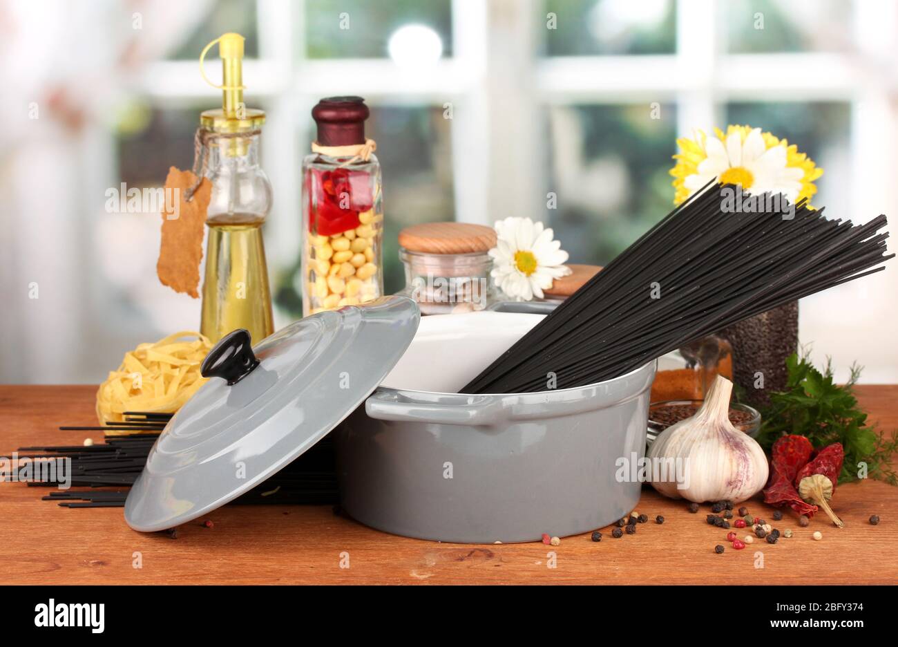 spaghetti in pan on wooden table on bright background Stock Photo - Alamy