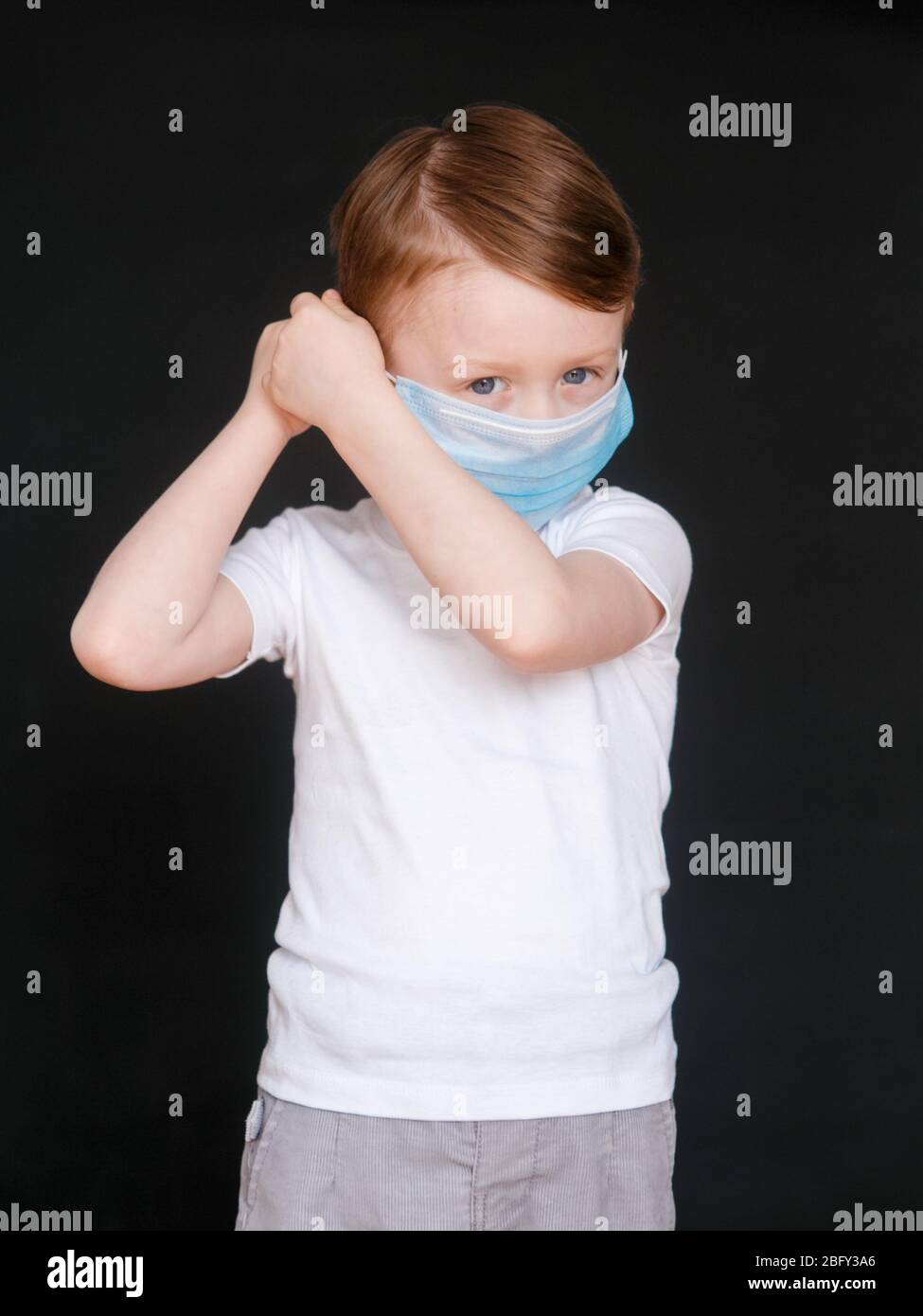 A little boy is holding a medical mask. Baby wears face masks covid-19 ...