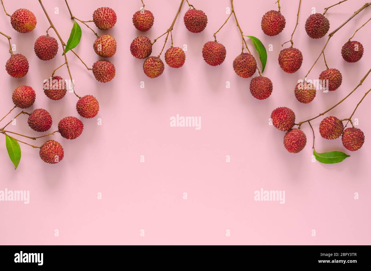 Fresh lychee fruits with stem and leaves, exotic asian fruits on pink ...