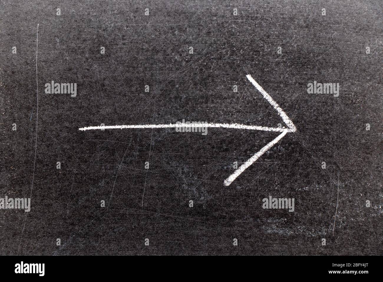 White chalk hand drawing in arrow shape on black board background Stock ...