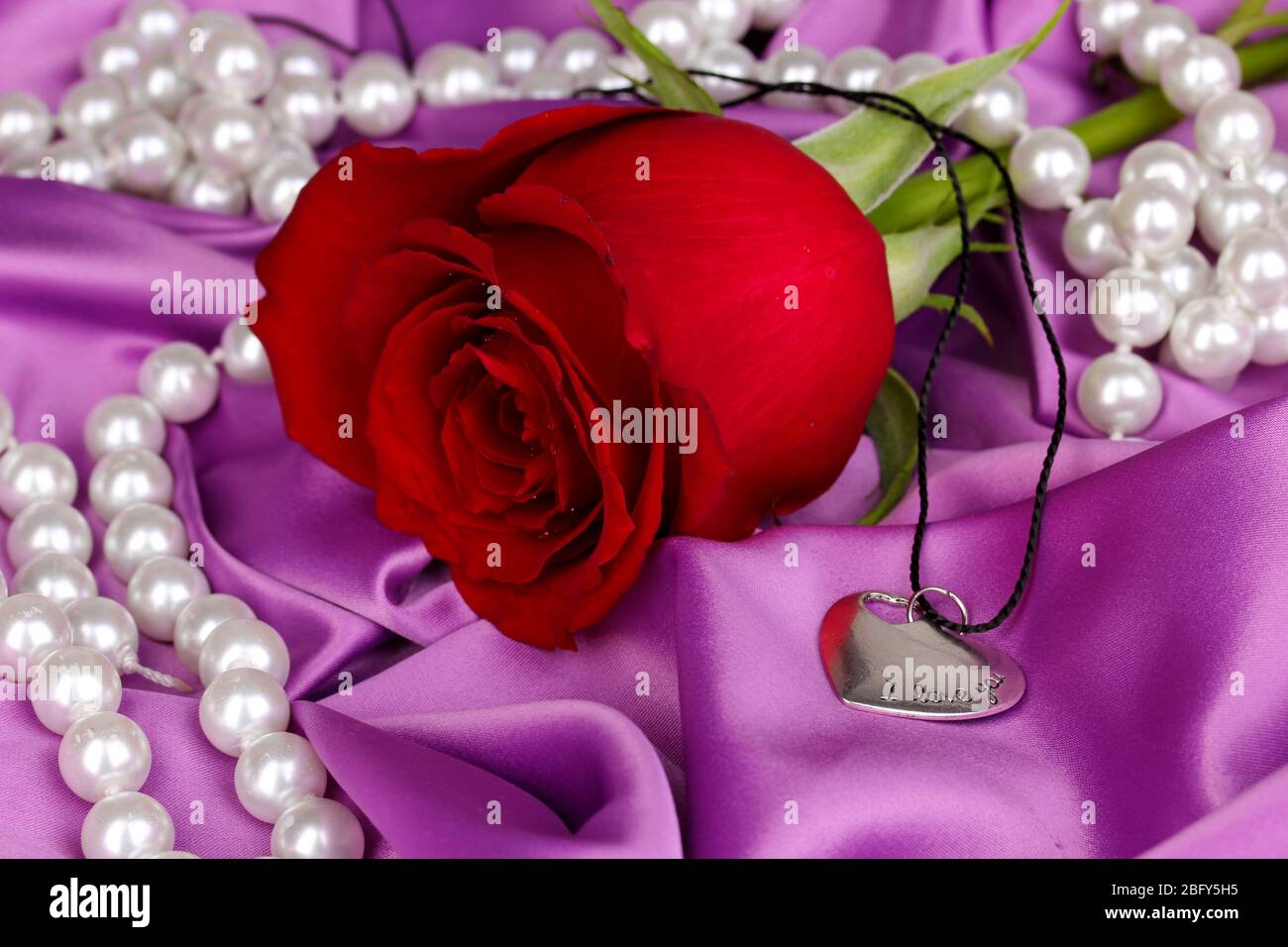 Heart pendant with red rose Stock Photo - Alamy