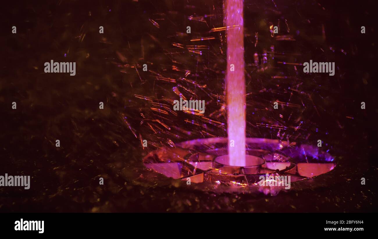 Splashes of colorful fountain. Water illuminated in diverse colors ...