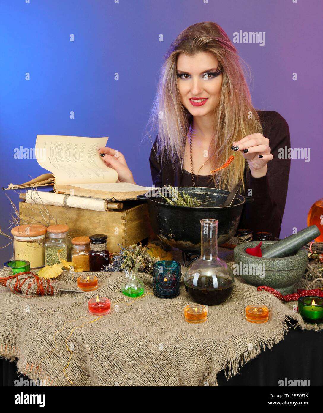 Halloween witch preparing poison soup in her cauldron on color ...