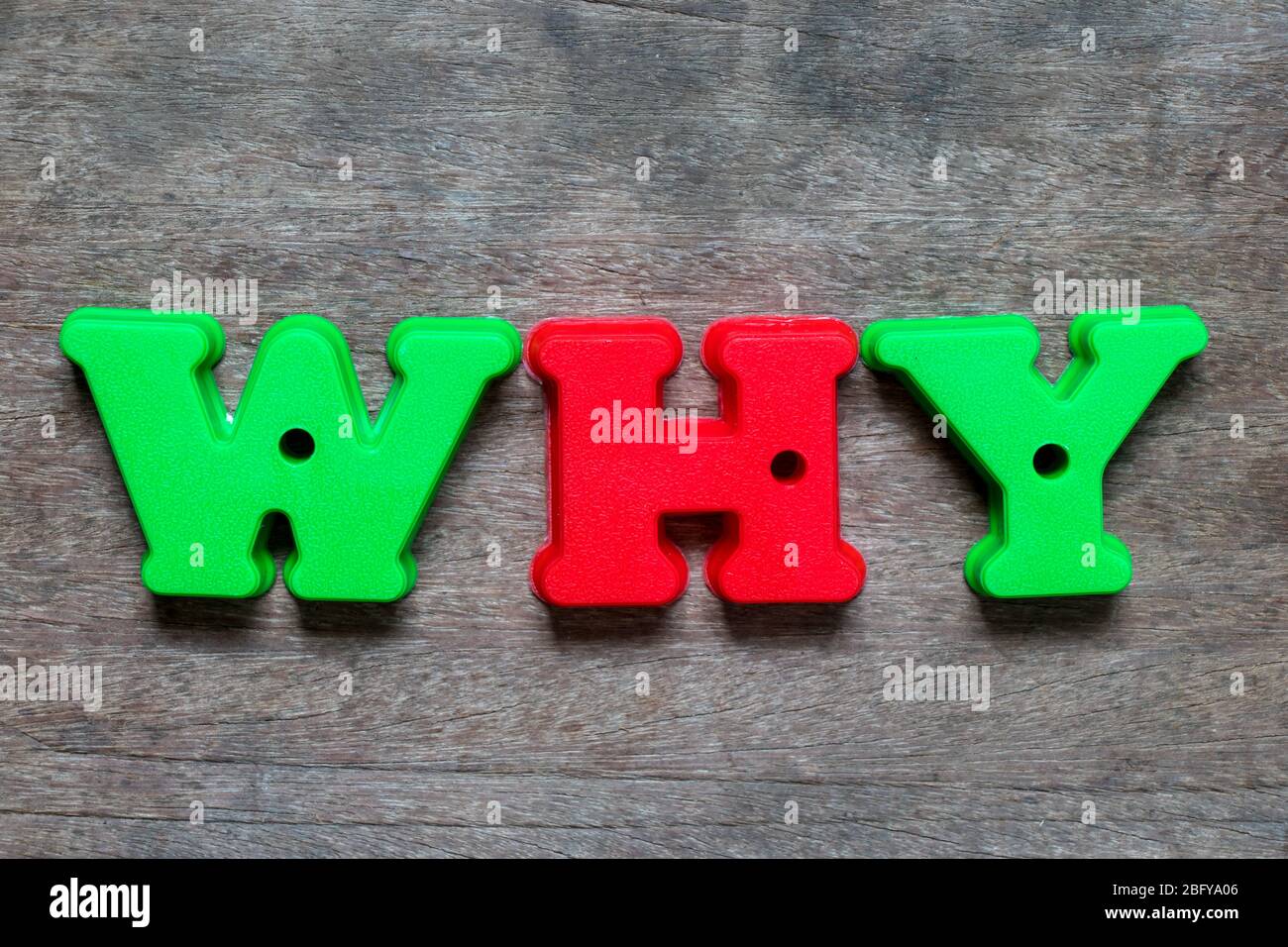 Color alphabet in word why on wood background Stock Photo - Alamy