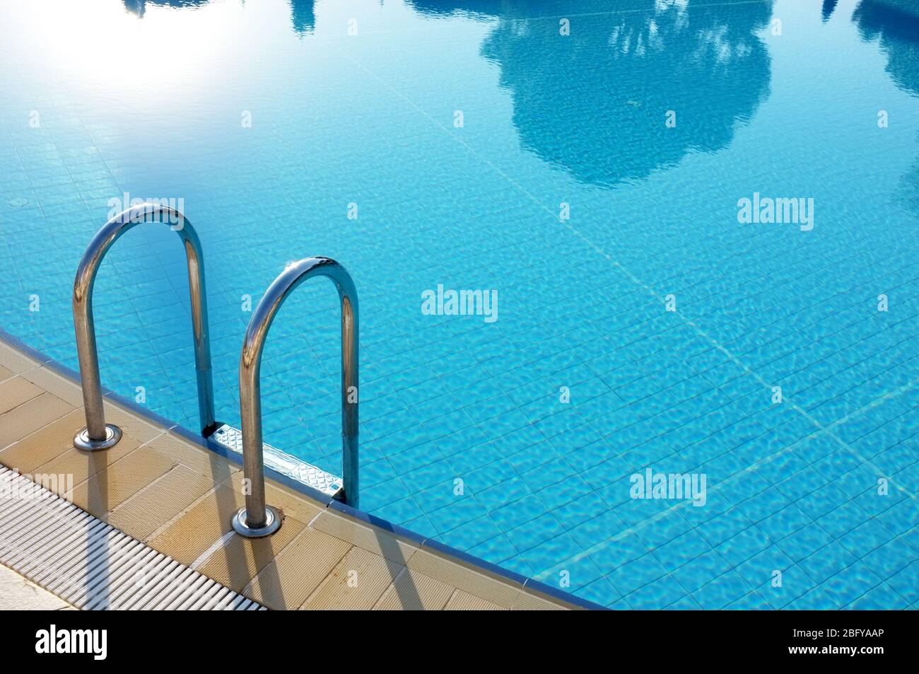 Hotel swimming pool with sunny reflections Stock Photo - Alamy