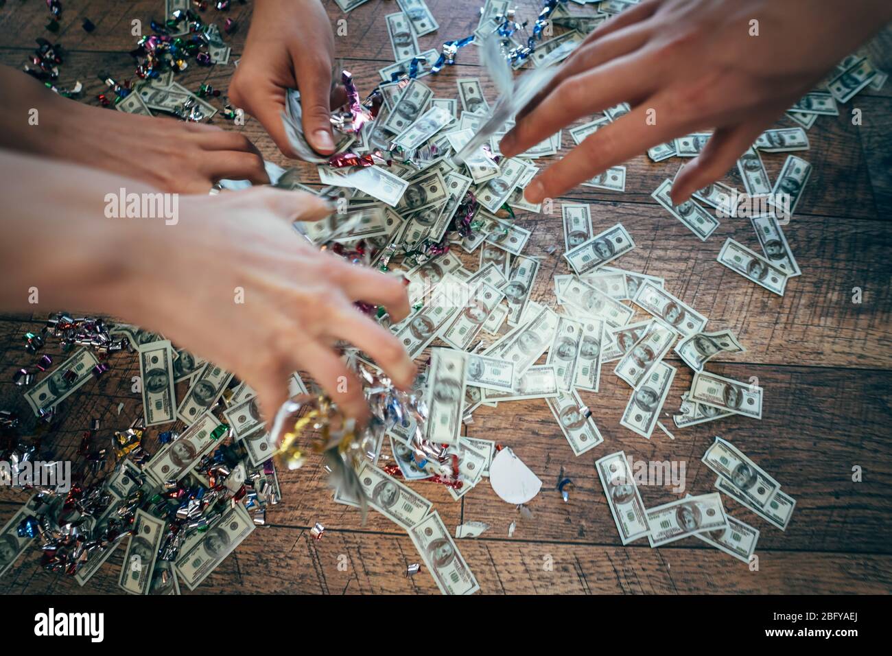 Several pairs of hands pick up dollar bills from the floor Stock Photo ...