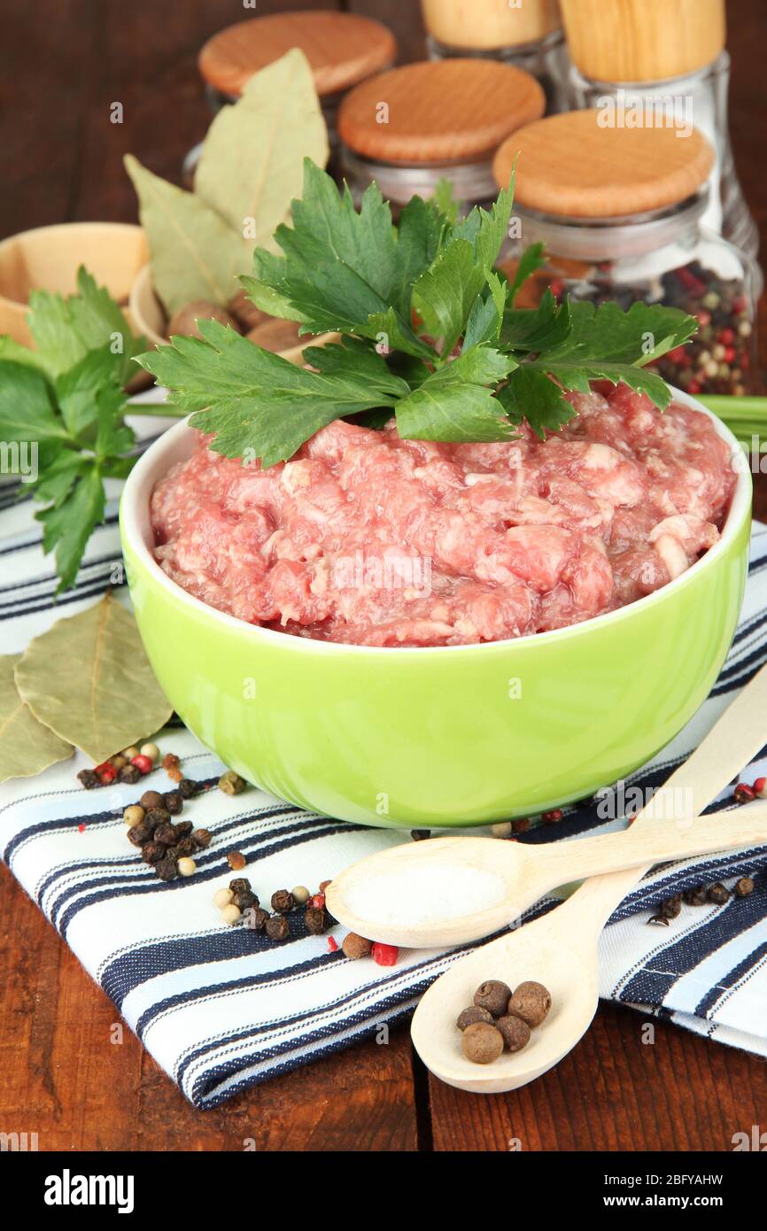 Bowl of raw ground meat with spices on wooden table Stock Photo - Alamy
