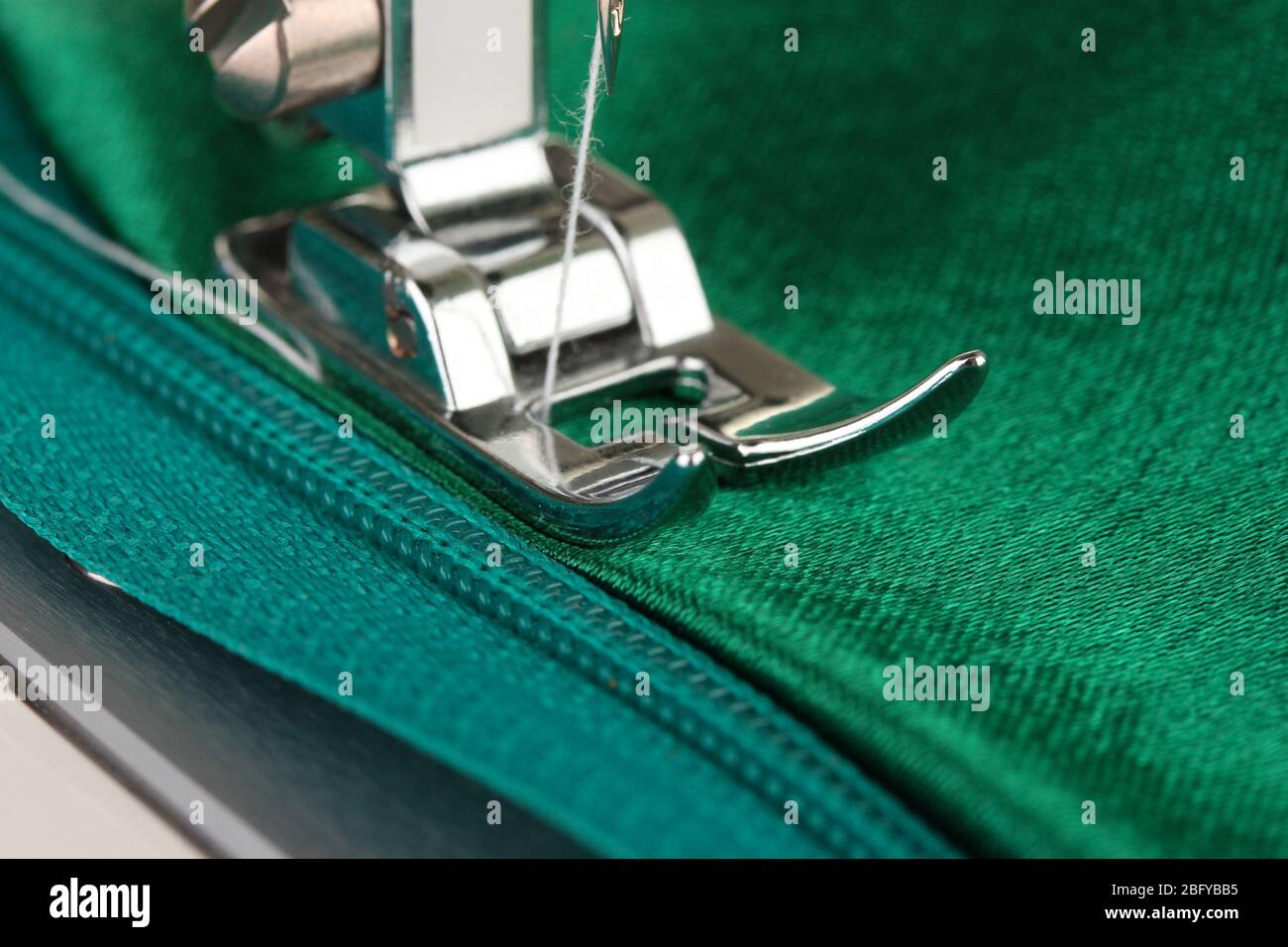 Closeup of sewing machine working part with green cloth Stock Photo - Alamy