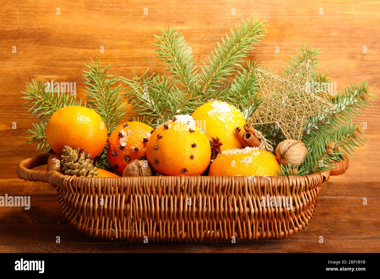 christmas composition in basket with oranges and fir tree, on wooden ...