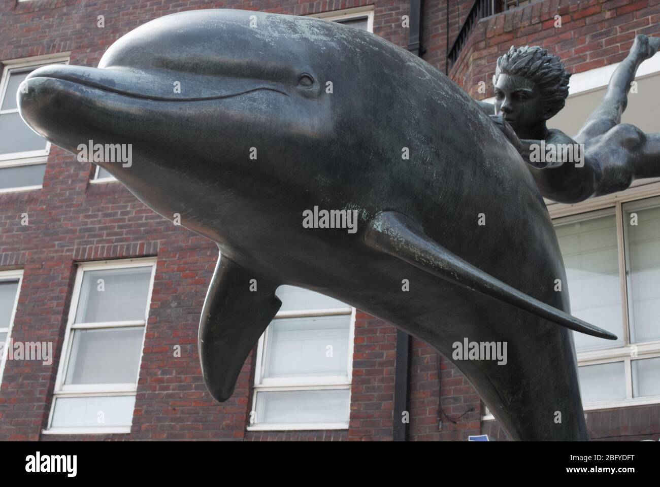 Dolphin and boy statue hi-res stock photography and images - Alamy