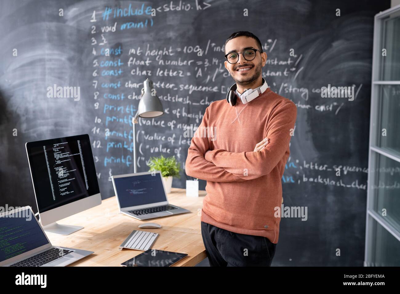 Portrait of satisfied young middle-eastern computer programmer with ...