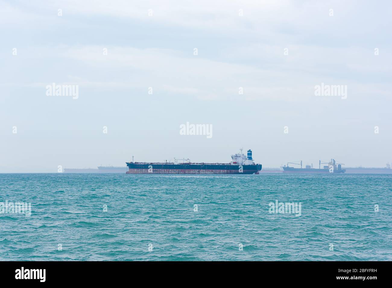 Cargo ships, oil tankers and bulk carriers anchored offshore along the ...