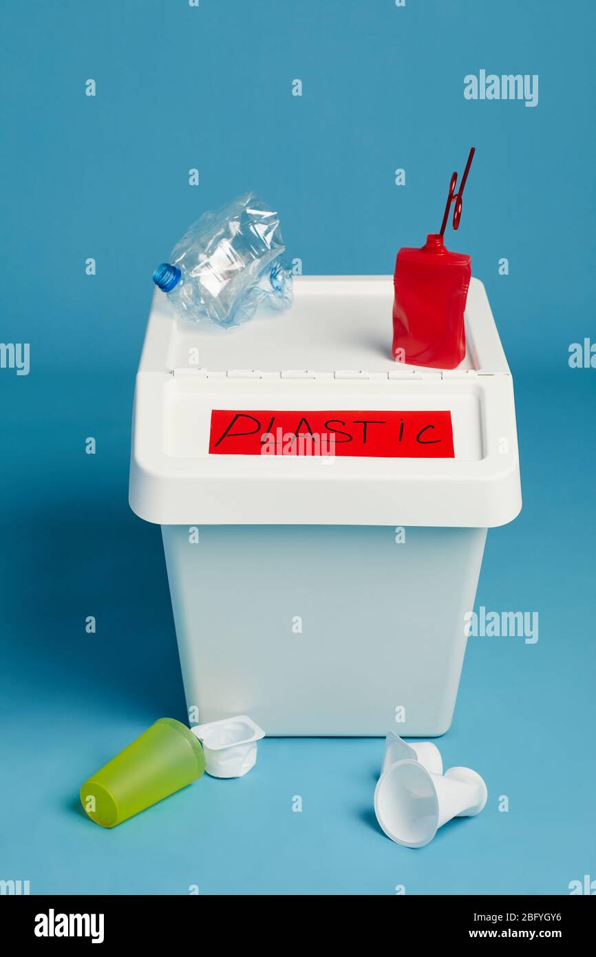 Full length view at labeled trash bin for plastic waste against blue ...
