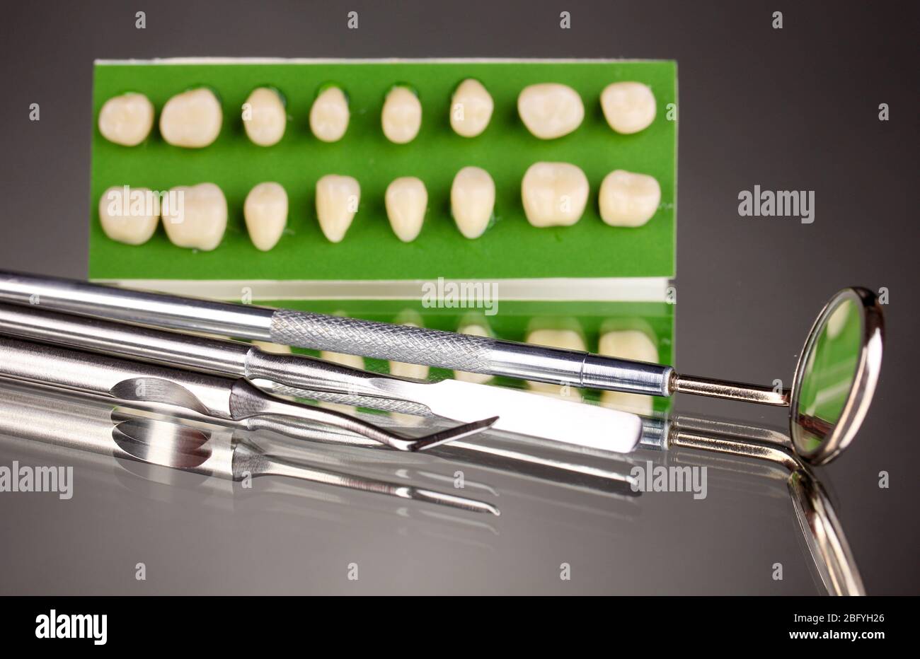 Set of dental tools with denture on grey background Stock Photo - Alamy