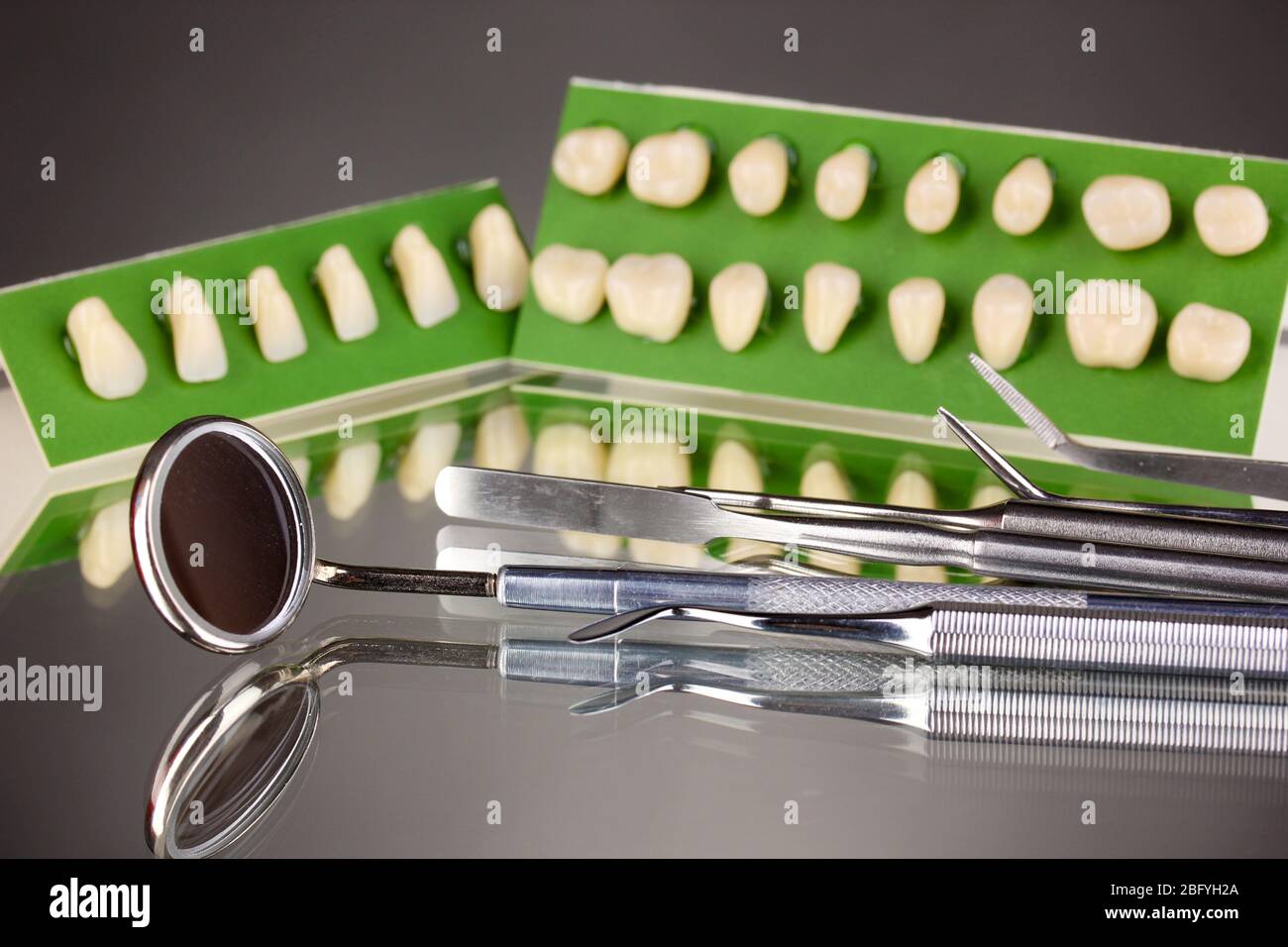 Set of dental tools with denture on grey background Stock Photo - Alamy