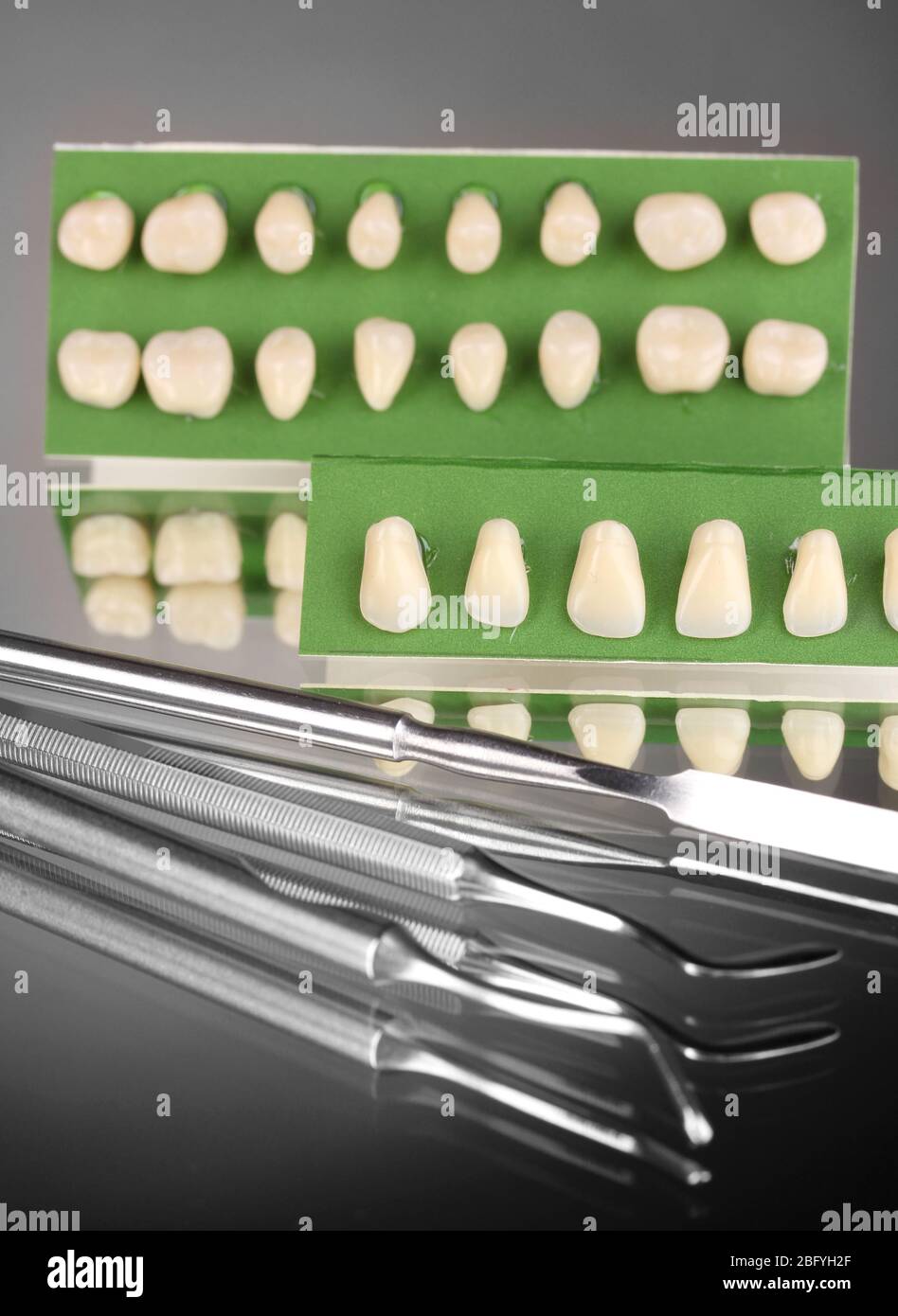 Set of dental tools with denture on grey background Stock Photo - Alamy