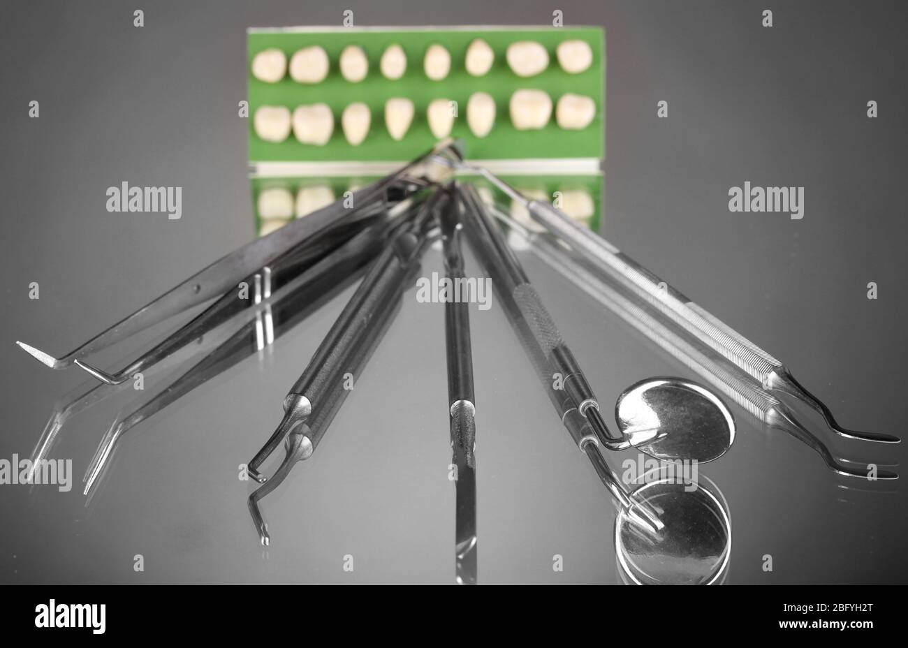 Set of dental tools with denture on grey background Stock Photo - Alamy