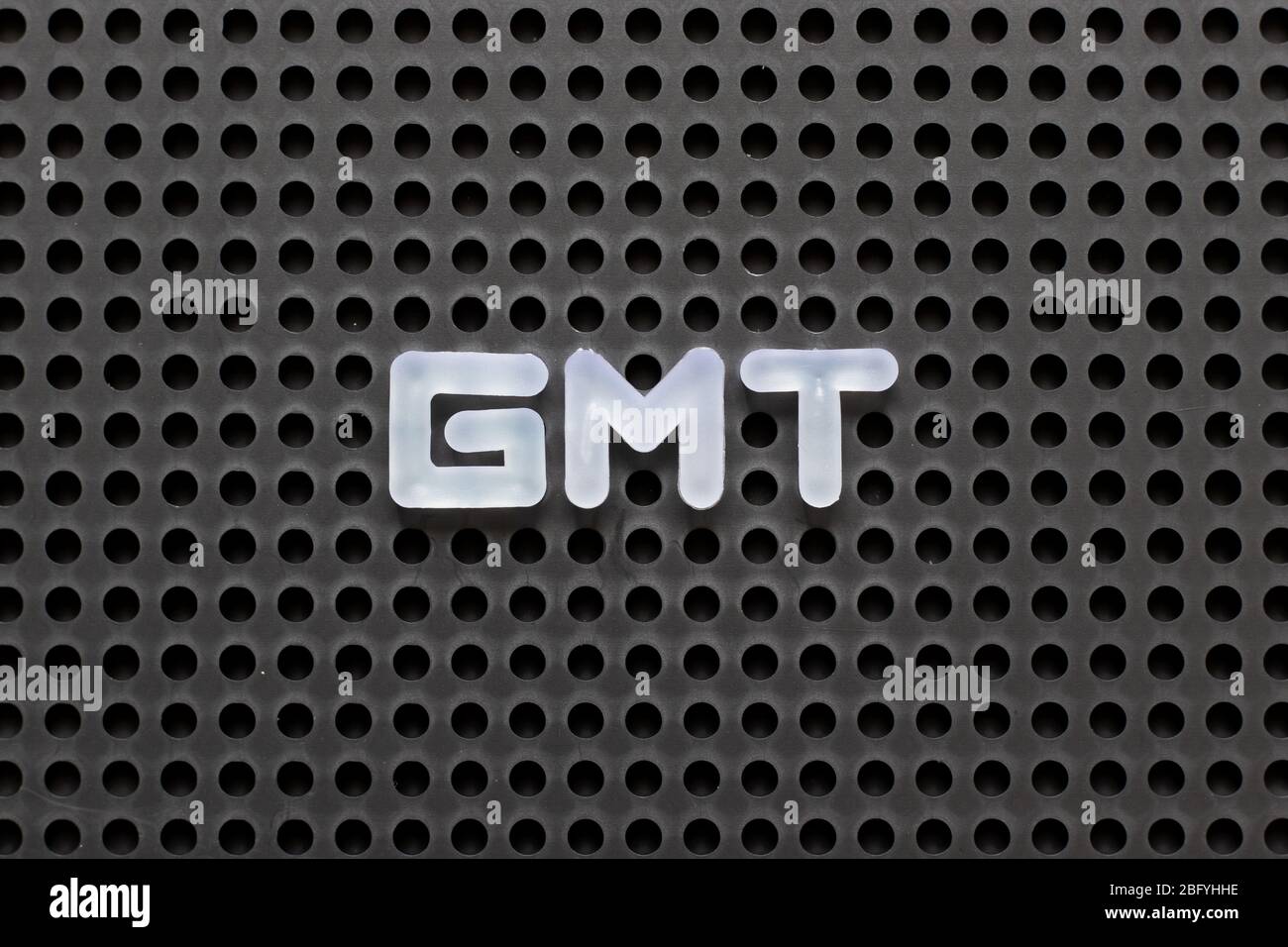 Black color pegboard with white letter in word GMT (abbreviation of ...