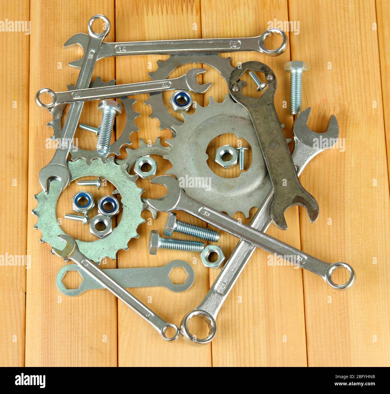 Machine gear, metal cogwheels, nuts and bolts on wooden background ...