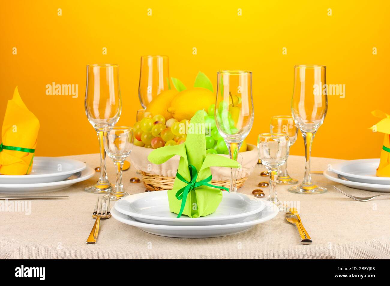 Table setting in green and yellow tones on color background Stock Photo ...