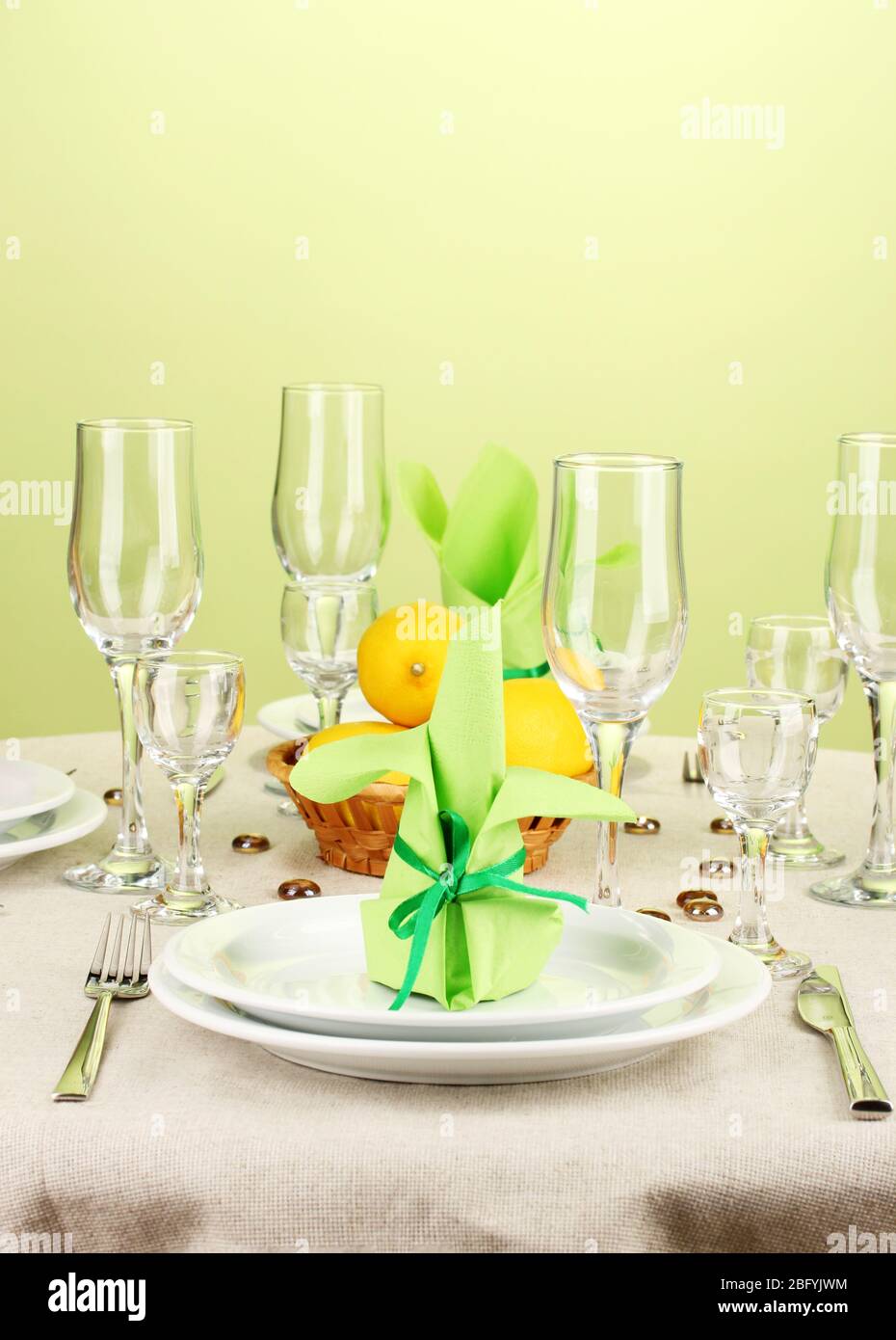 Table setting in green and yellow tones on color background Stock Photo ...
