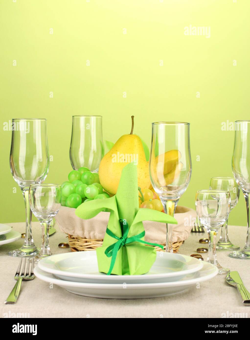 Table setting in green and yellow tones on color background Stock Photo ...