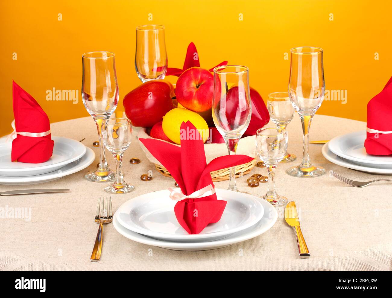 Table setting in red tones on color background Stock Photo - Alamy