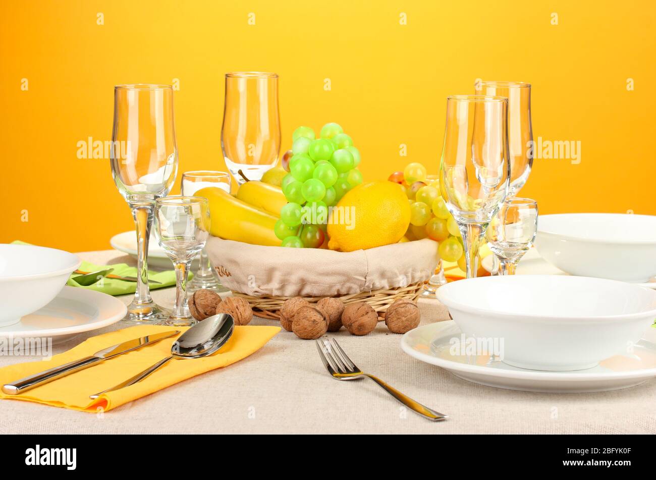 Table setting in green and yellow tones on color background Stock Photo ...