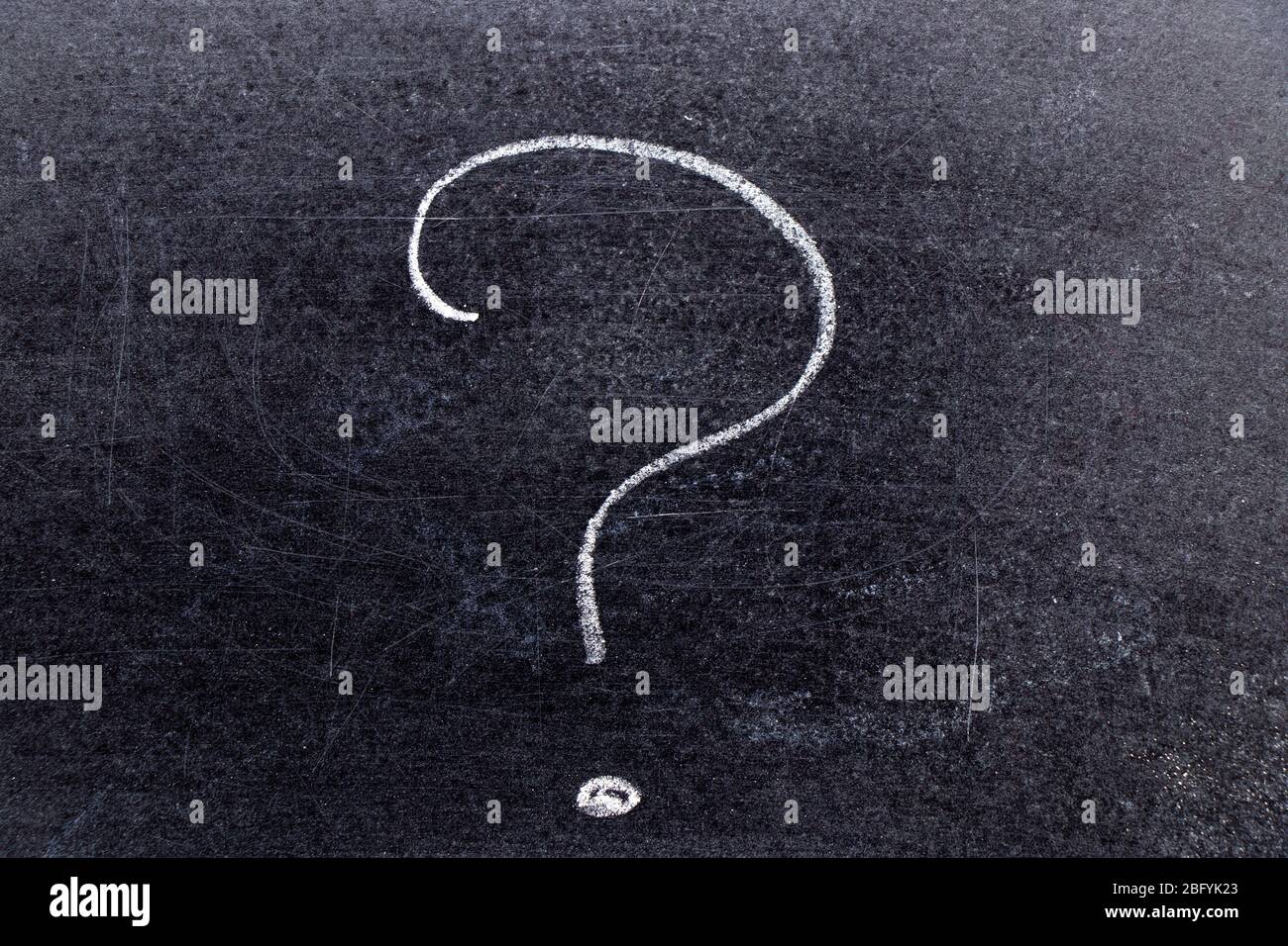 White chalk hand drawing in question mark shape on black board ...