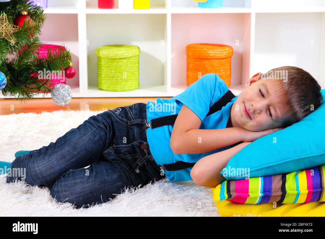 Little boy sleeping under Christmas Tree waiting for Santa Claus to ...