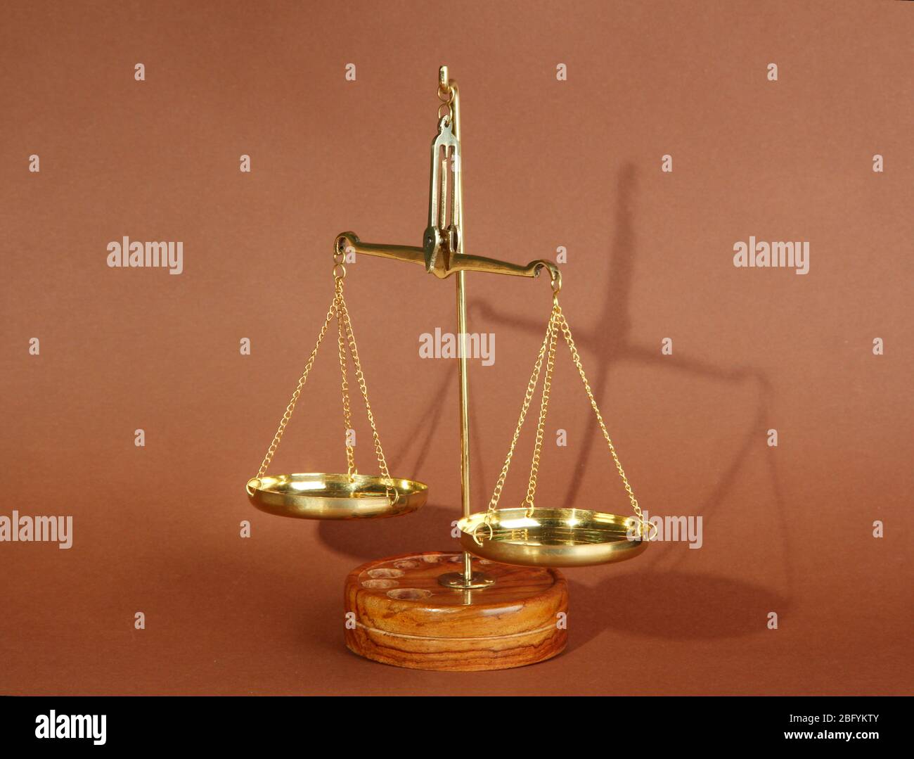 Gold scales of justice on brown background Stock Photo - Alamy
