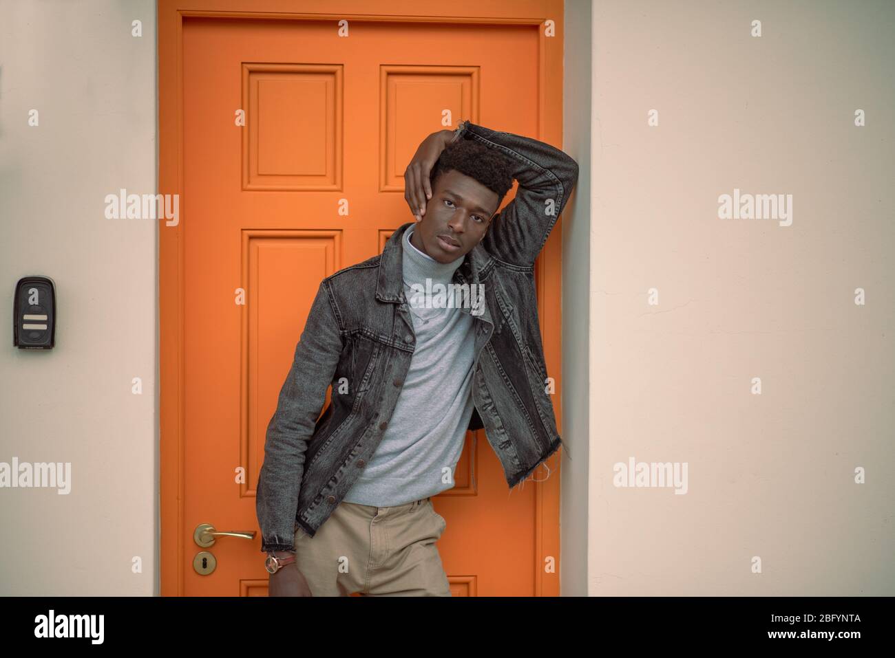 Portrait fo fashionable african man standing against door Stock Photo ...