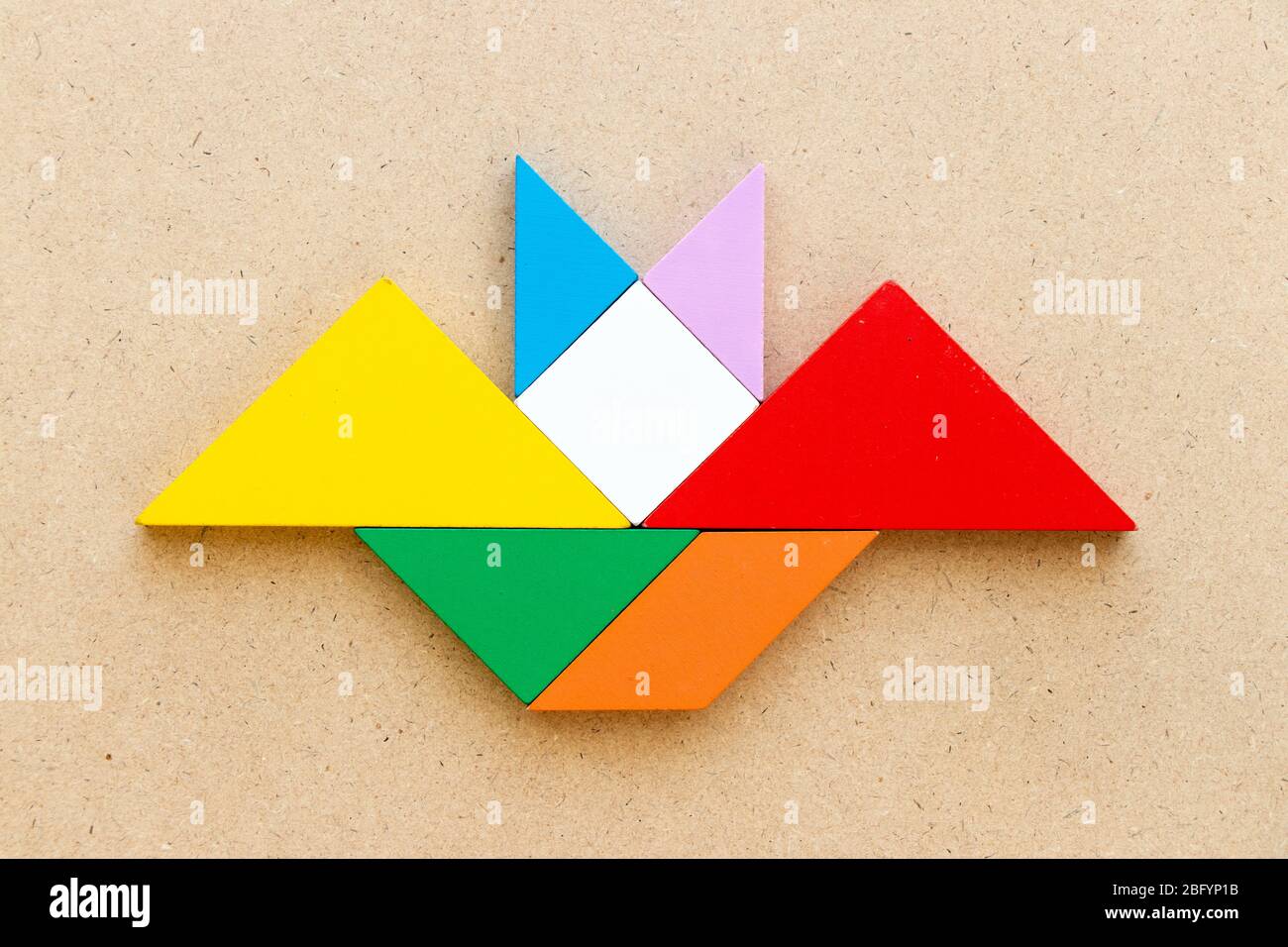 Color tangram in flying bat shape on wood background Stock Photo - Alamy