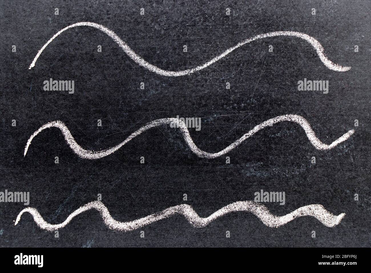 White chalk hand drawing in curve line shape on black board background ...