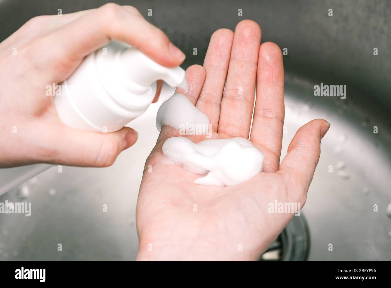 Putting whip foam soap bottle with foam on female hand. Lady using ...