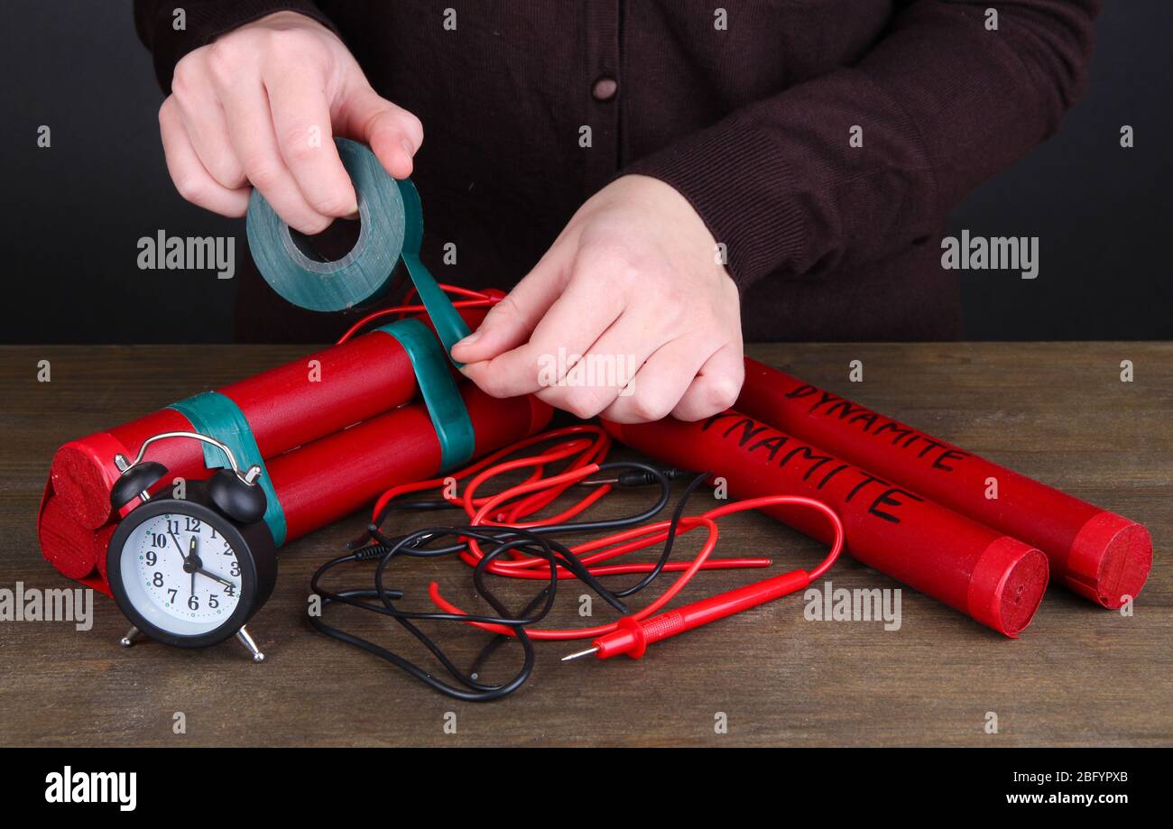 Human makes timebomb on wooden table on black background Stock Photo ...