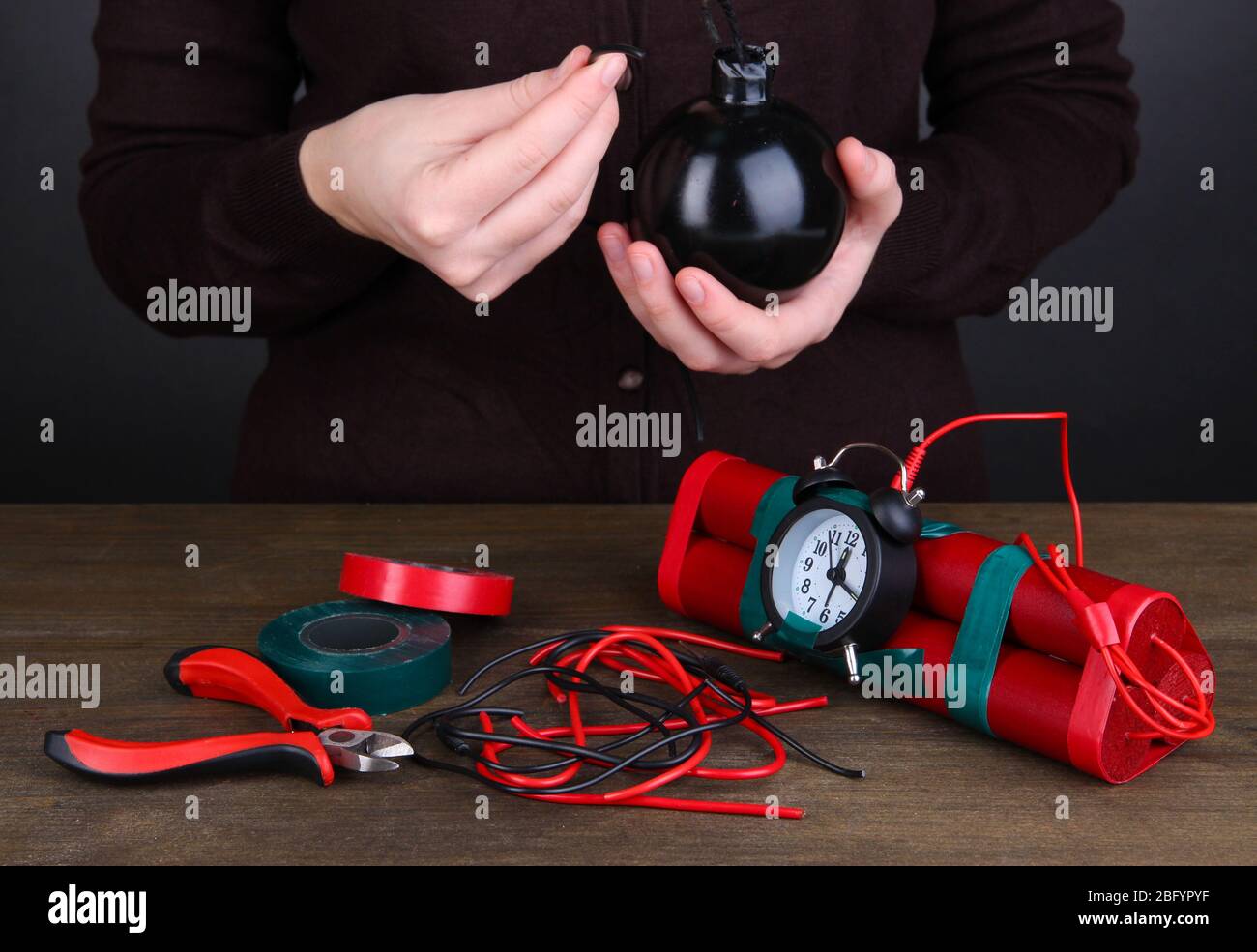 Human makes timebomb on wooden table on black background Stock Photo ...