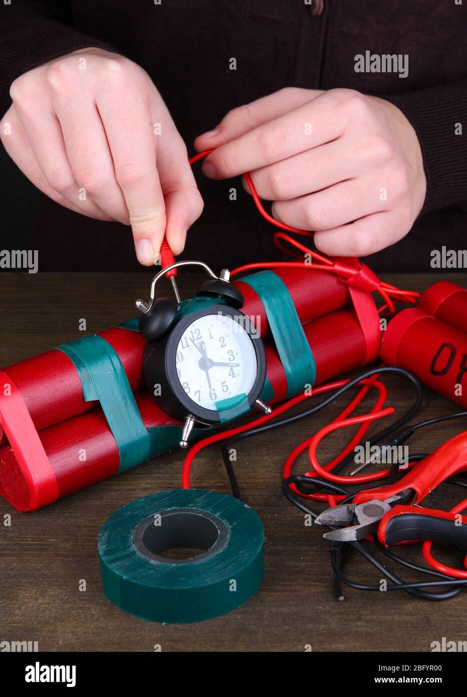 Human makes timebomb on wooden table on black background Stock Photo ...