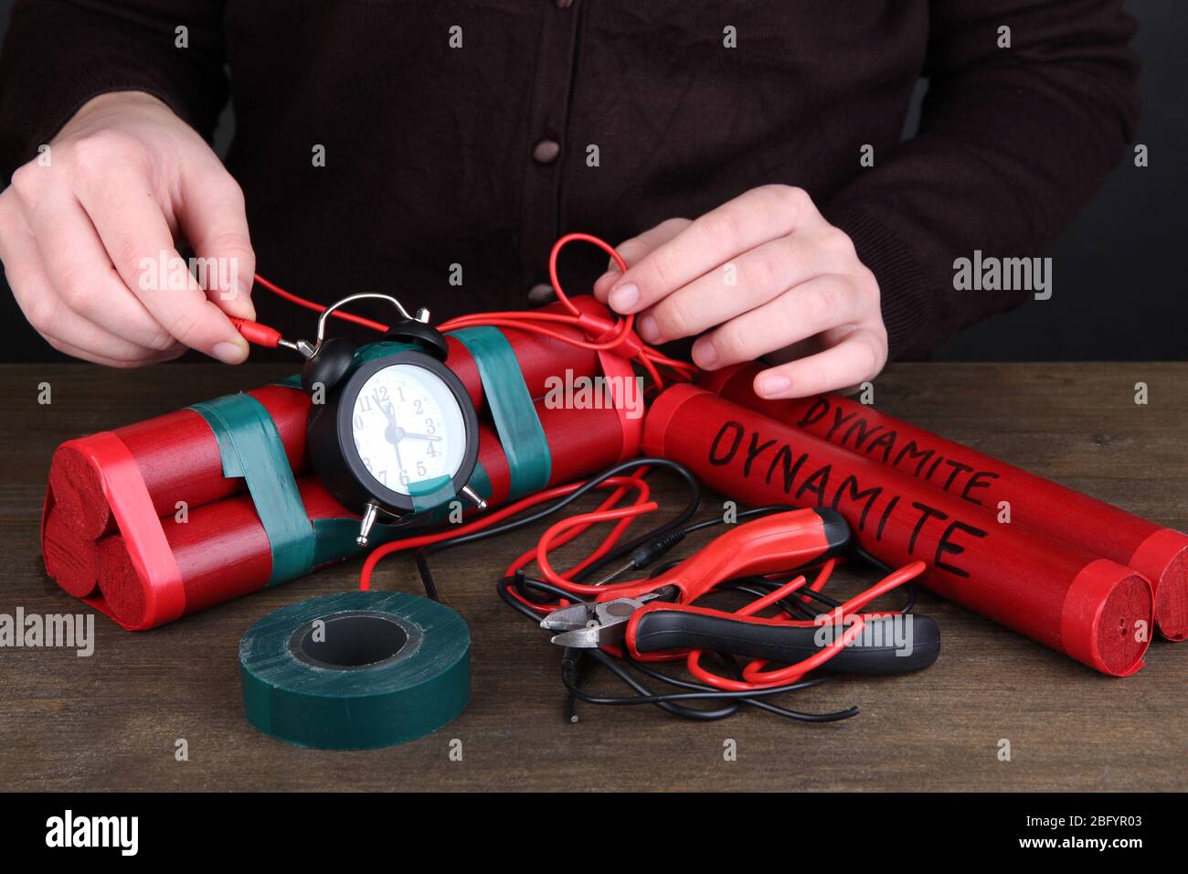 Human makes timebomb on wooden table on black background Stock Photo ...