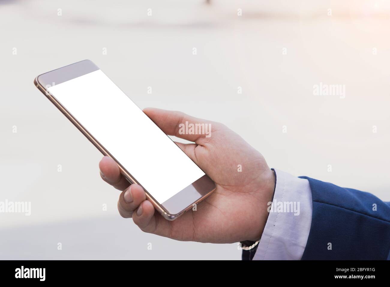 Closeup business man holding smartphone with white screen in the modern ...