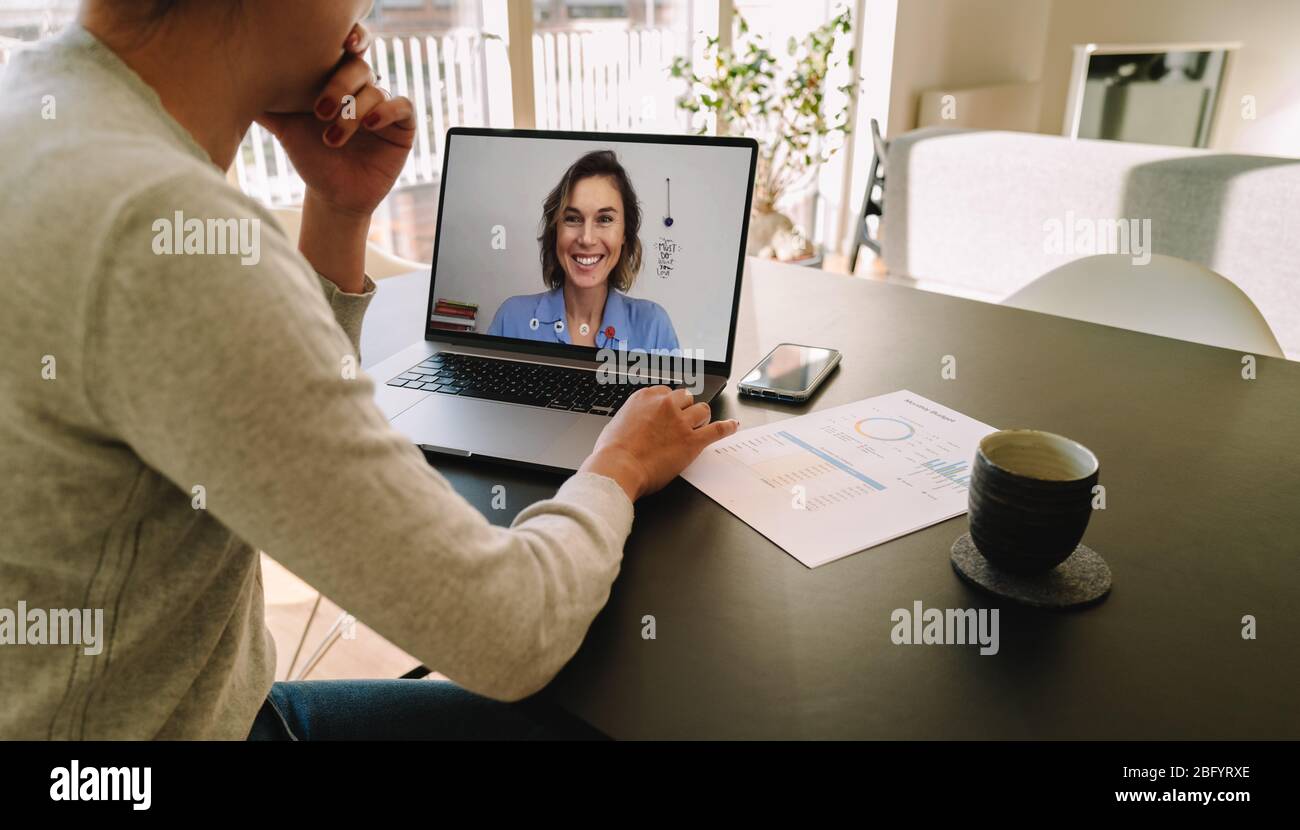 Woman teleconferencing with female colleague on laptop. Colleagues ...
