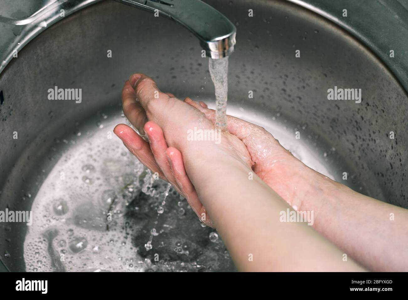 Close up of woman washing hands In kitchen Sink. Human hands being ...