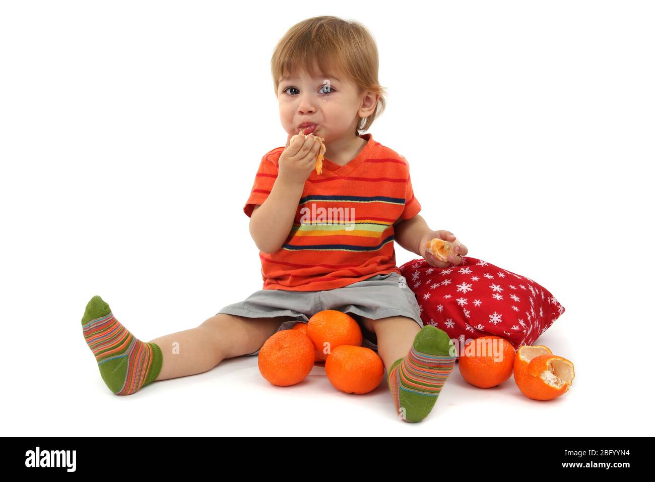 cute little boy eating tangerines, isolated on white Stock Photo - Alamy