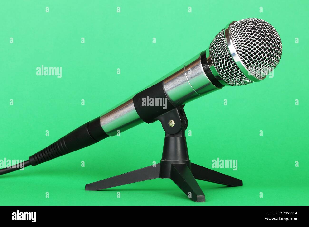 Microphone on green background Stock Photo - Alamy
