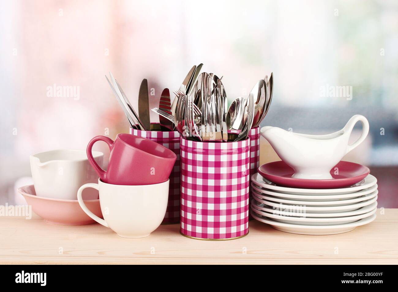 Cups, bowls nd other utensils in metal containers isolated on light ...