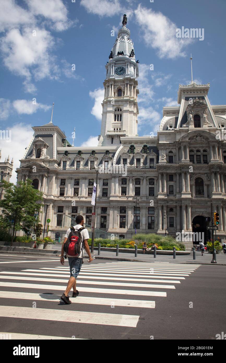 Vertical shot of a man crossing the street in front of the Town Hall ...