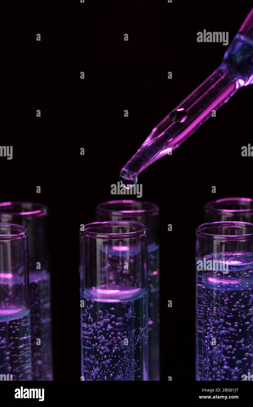 test-tubes with liquid on black background Stock Photo - Alamy
