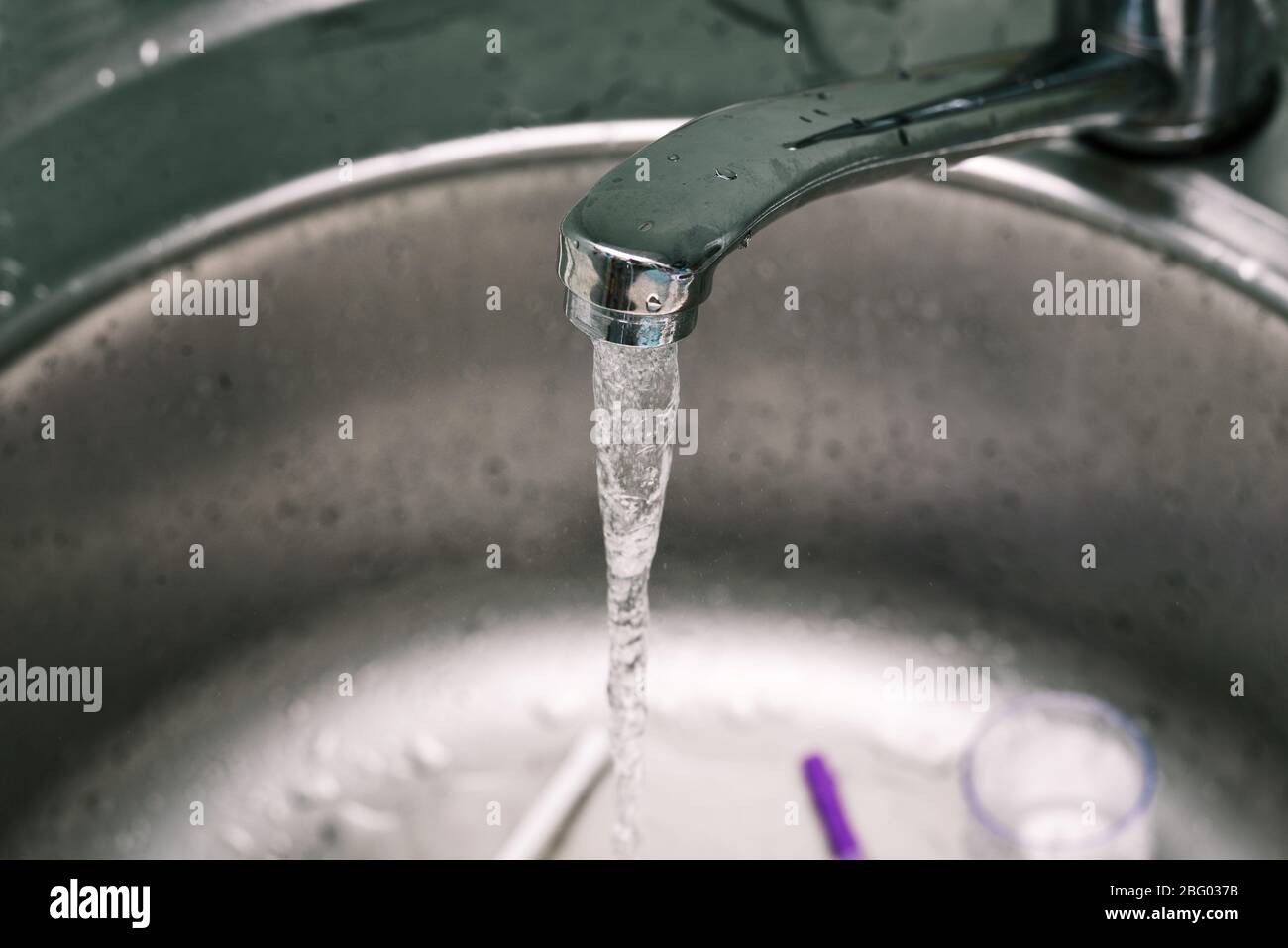 Water drop from faucet in the kitchen. Water from the tap. A stream of ...