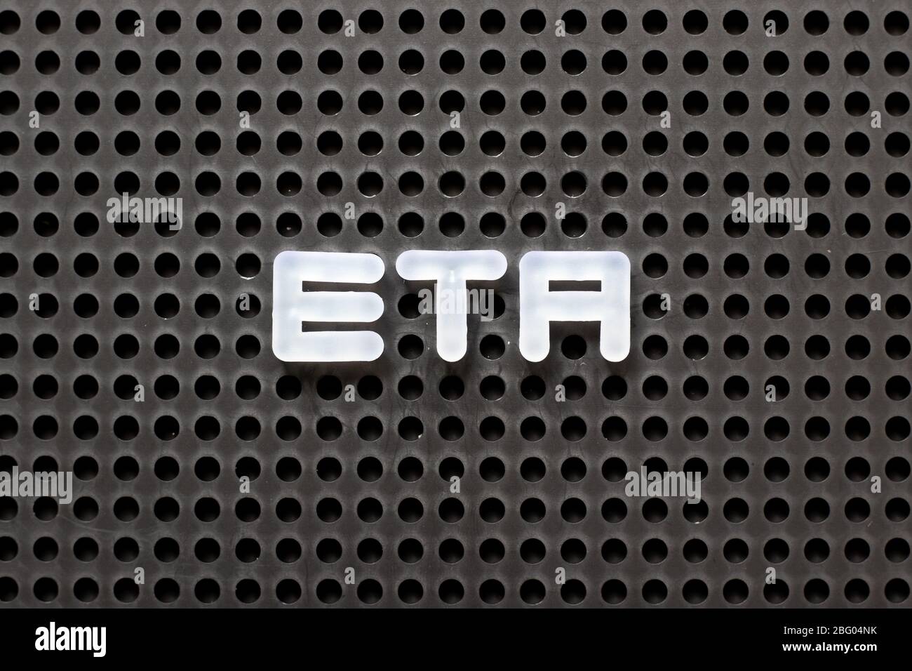 Black color pegboard with white letter in word ETA (Estimated time of ...