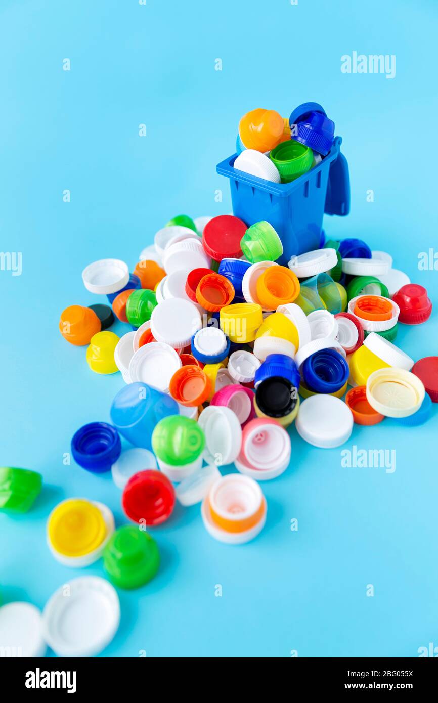 Miniature recycling container filled with plastic bottle caps of ...